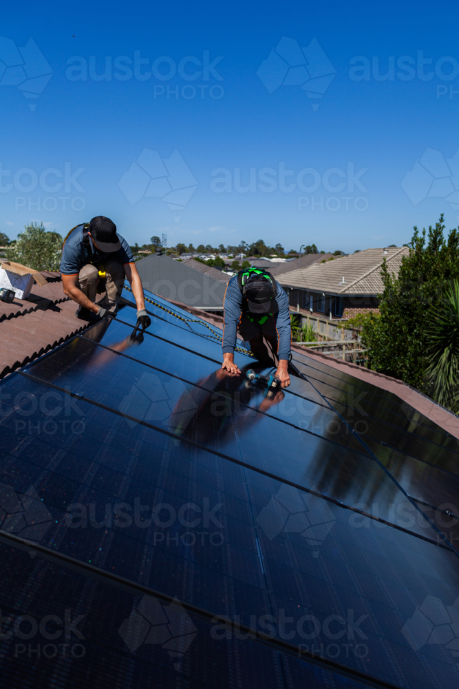 Image of Solar panel technician with drill installing solar panels on ...