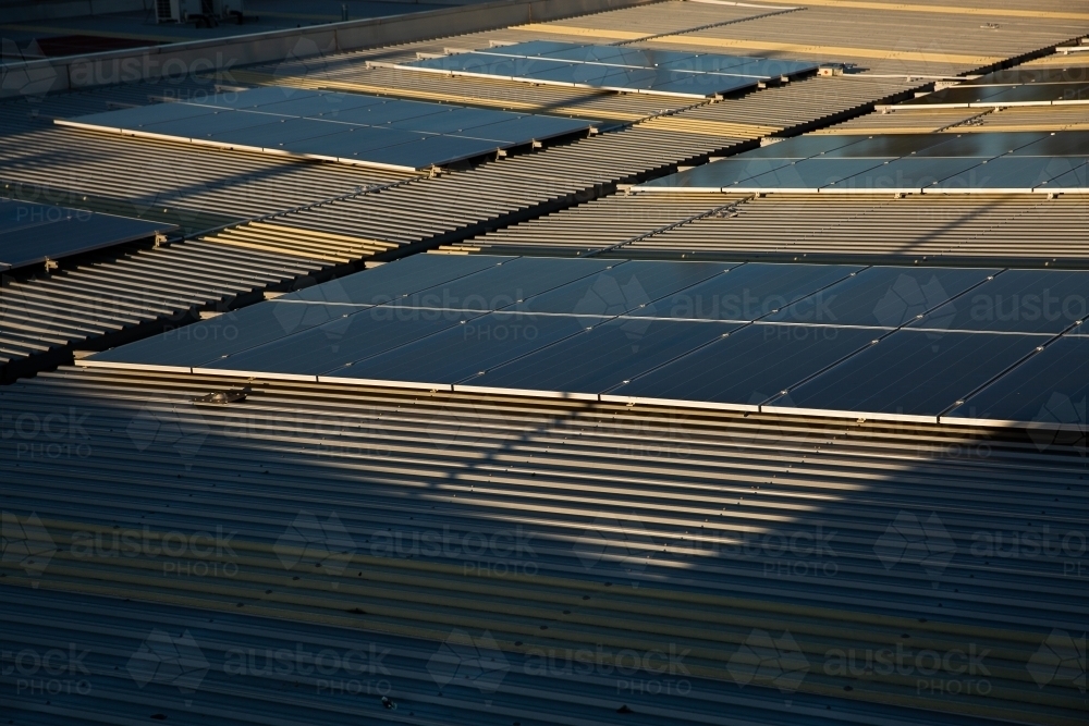 Image of solar panels in the sun on a metal roof - Austockphoto