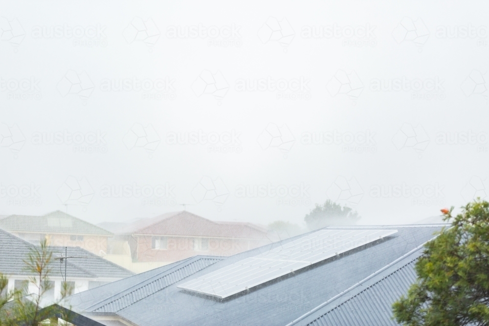 Image of Solar panels on roof in rain storm with overcast sky ...