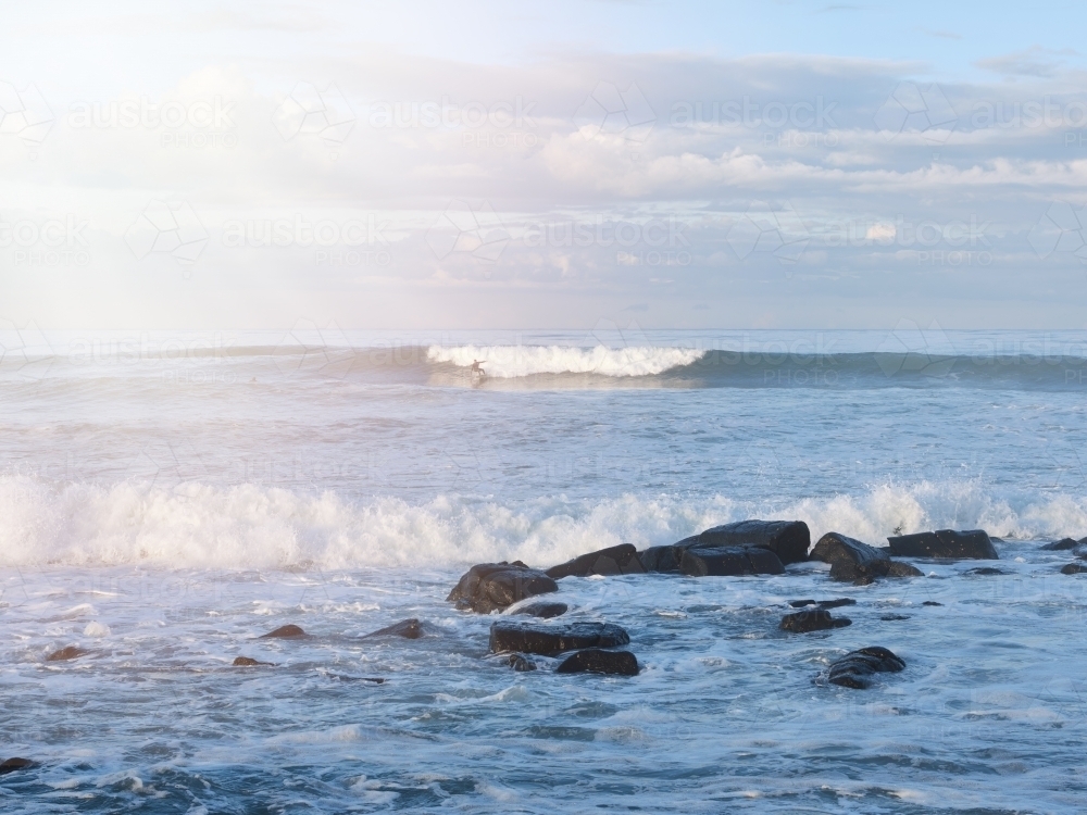 Image of Solo surfer on wave at dawn - Austockphoto