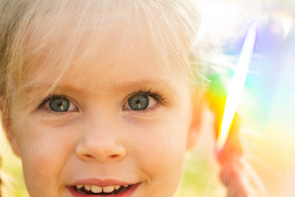 Image of Sparkling rainbow light beside happy young Aussie child ...