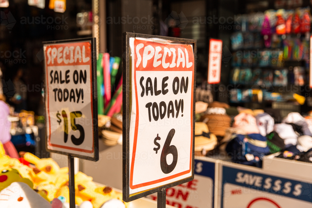Image of special sale signs in golden sunlight in front of a shop ...