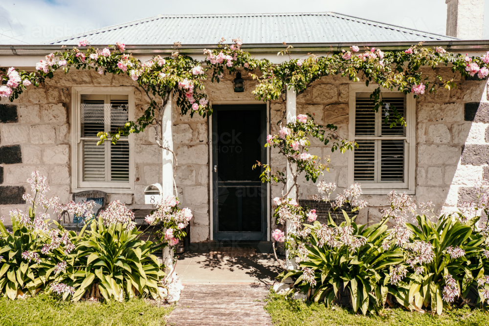 Image of Stone cottage porch with flowering vines and grassy front yard ...