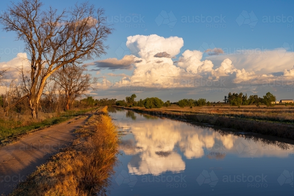 Image of Storm clouds reflected in the water of an irrigation channel ...