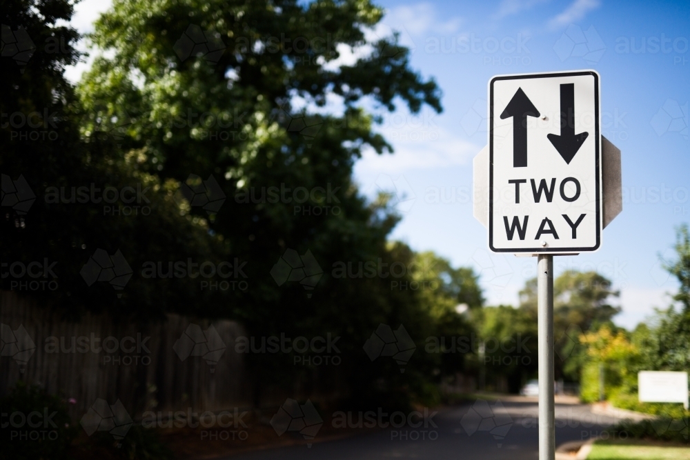Image of Street sign directing traffic two ways - Austockphoto