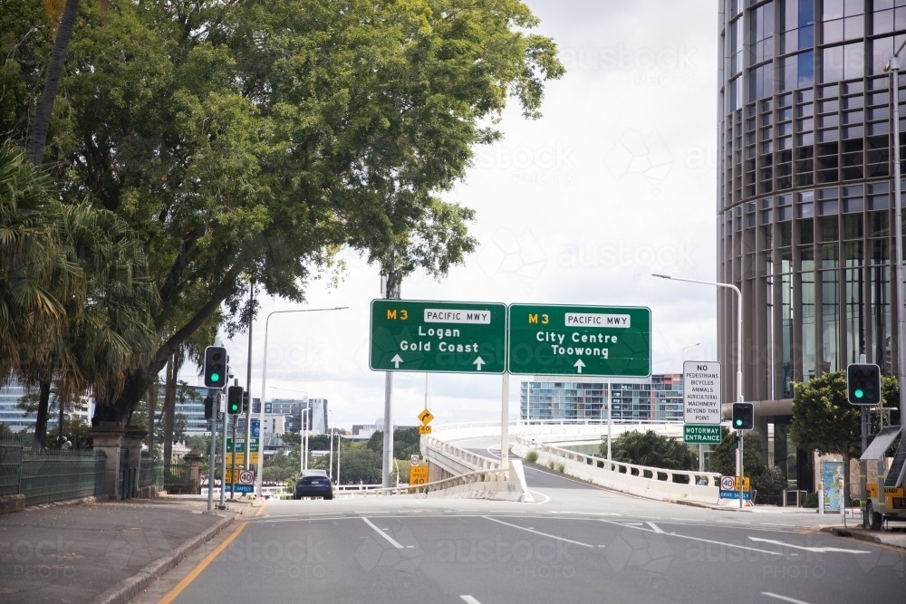 Image of street signs over car on road leaving Brisbane City - Austockphoto