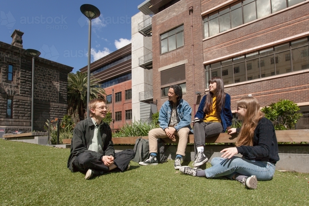 Image of Students relaxing on university grounds - Austockphoto