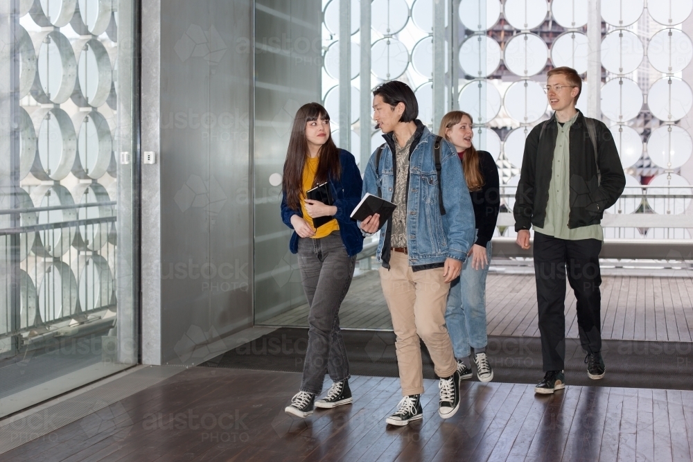 Image of students walking through university building - Austockphoto