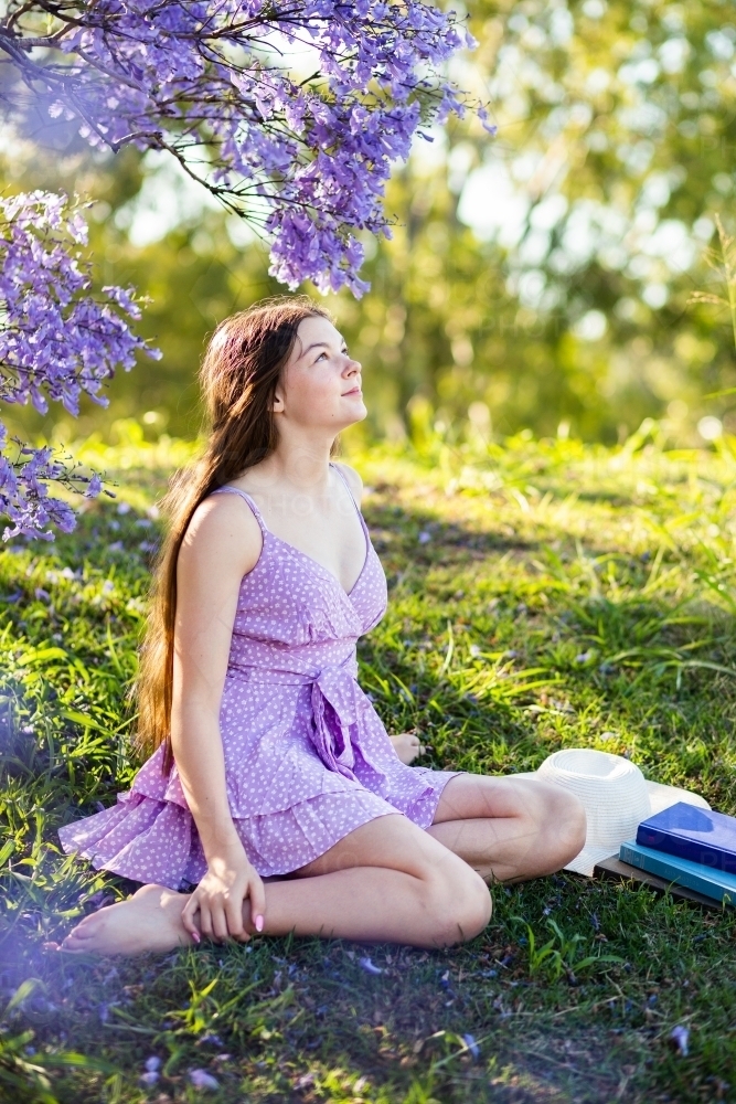 Image Of Summer Scene Of Teen Girl Sitting On Grassy Slope Relaxing
