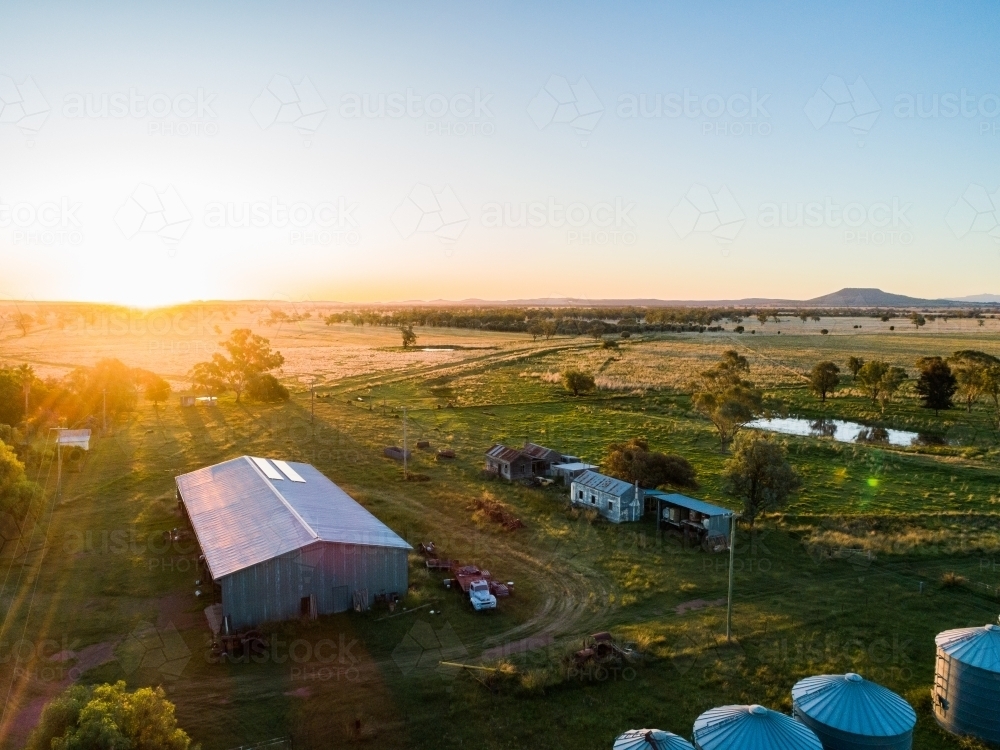 Image of Sun on the horizon with rays of golden light shining over farm ...
