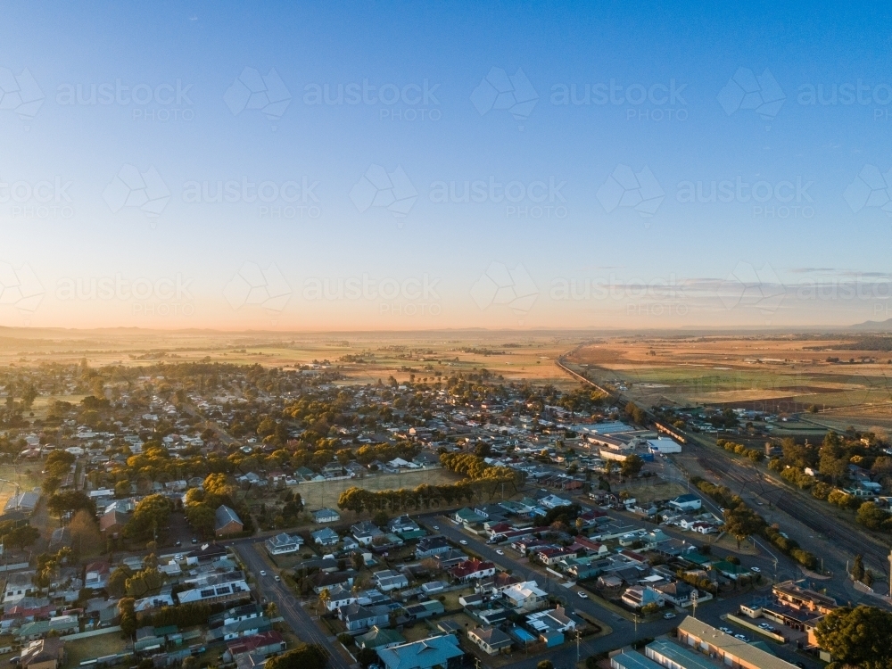 Image of Sun rising over country town and distant paddocks with train ...