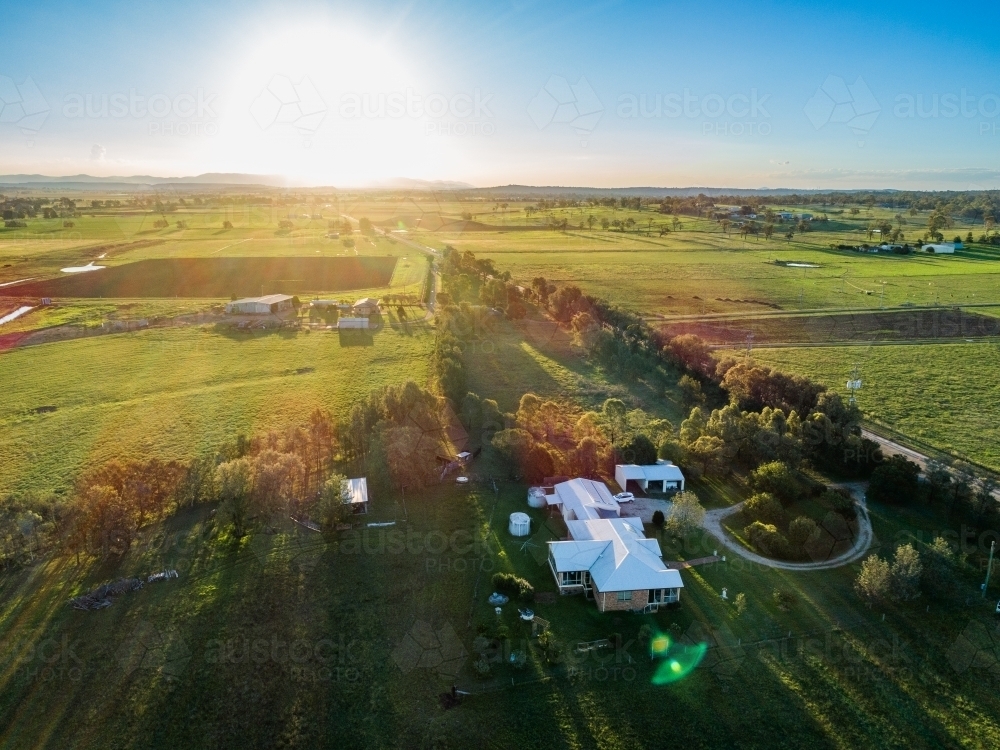 Image of Sunlight over farm house in green agricultural landscape ...