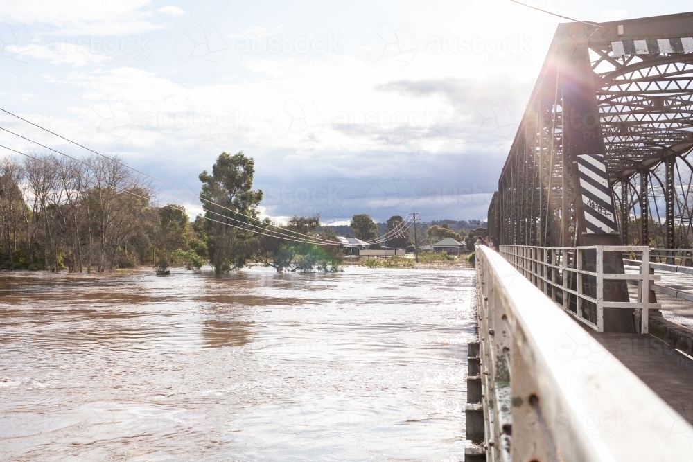 Image of Sunlight over old truss bridge in Singleton with floodwaters ...