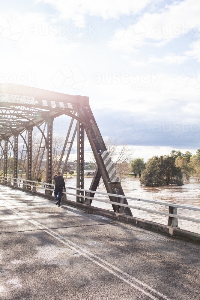 Image of Sunlight over old truss bridge in Singleton with floodwaters ...