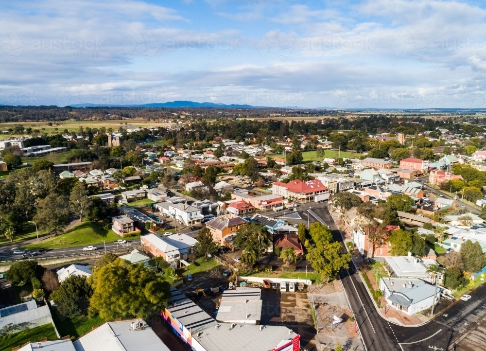 Image of Sunlit aerial view of street corner with shops, houses and pub ...