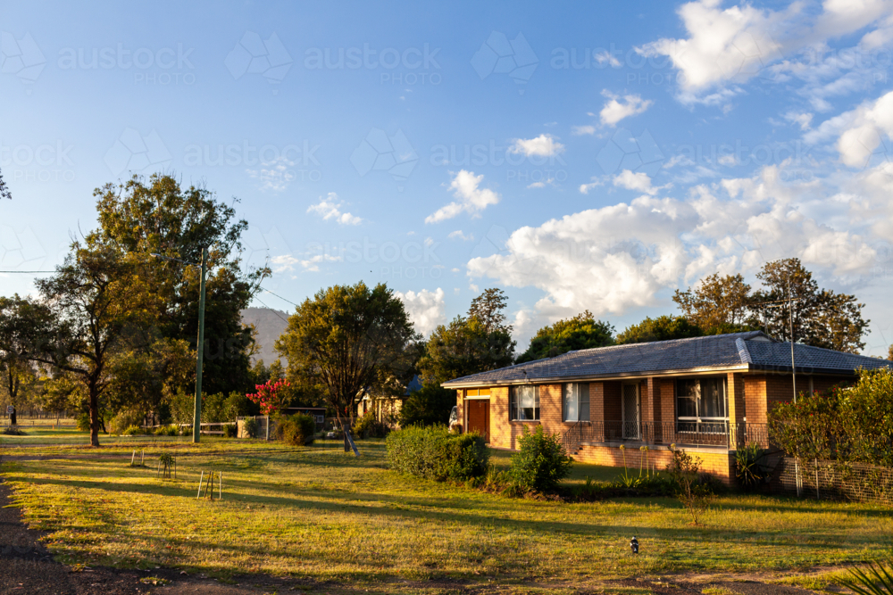 Image of Sunlit country scene of brick house in quiet rural village ...