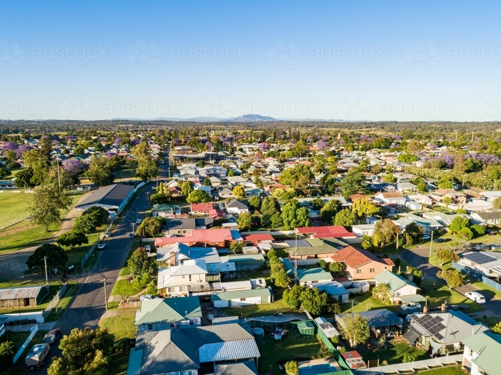 Image of Sunlit quiet suburban street in country town - Austockphoto