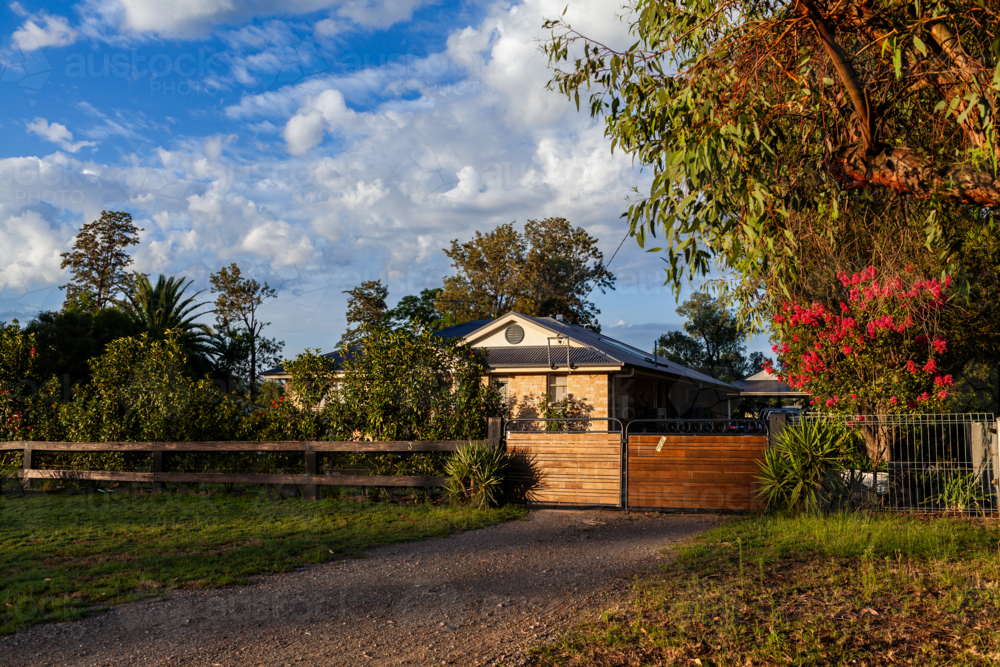 Image of Sunlit scene of brick house in quiet village hidden behind ...