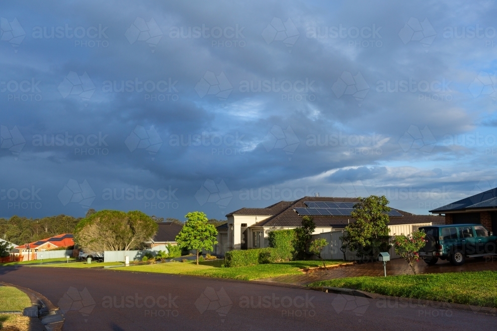 Image of Sunlit suburban street scene fresh after rain with storm ...