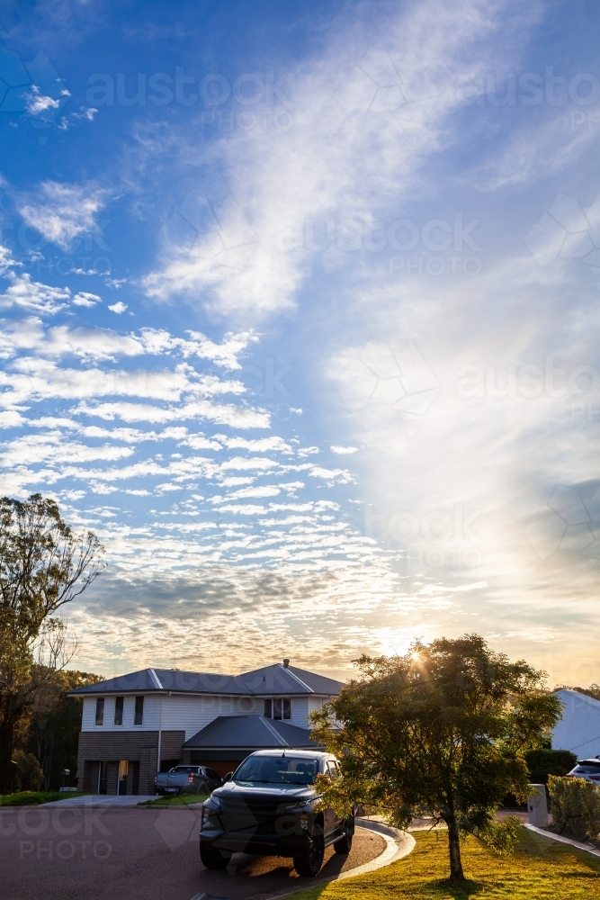 Image of Sunrise over suburban street with car tree and house below ...