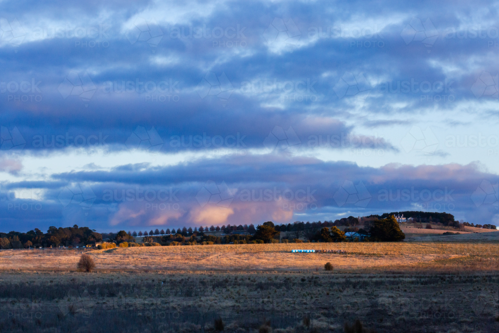 Image of Sunset light on paddock and hill with trees on ridge up to ...