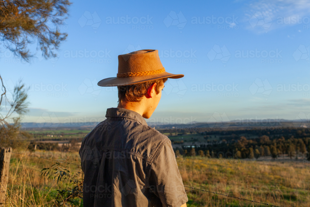 Image of Sunset light on side of teen boys face looking out over ...