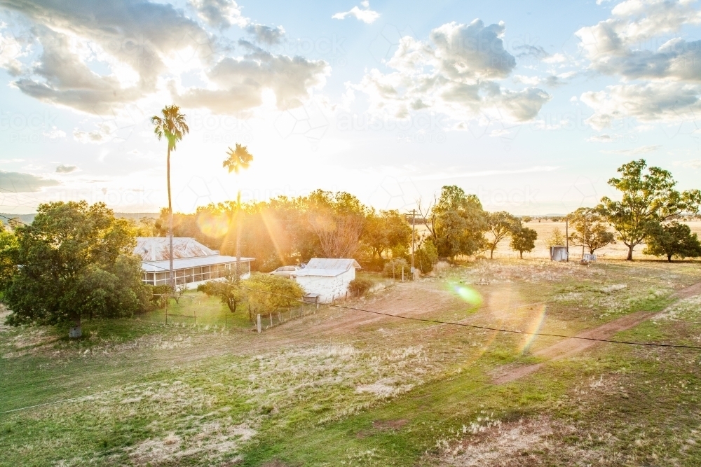 Image of Sunset over a farm homestead and paddock in the country ...