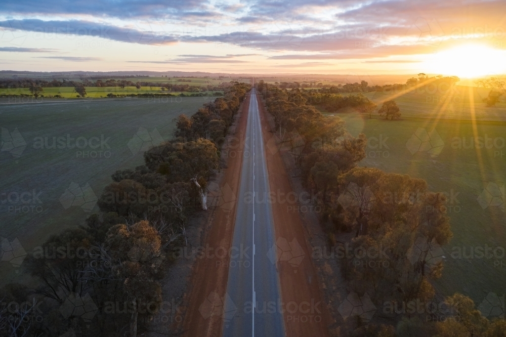 Image of Sunset Over Road Through Australian Farmland - Austockphoto