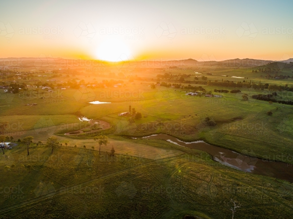 Image of Sunset over valley with dam and creek winding through paddocks ...