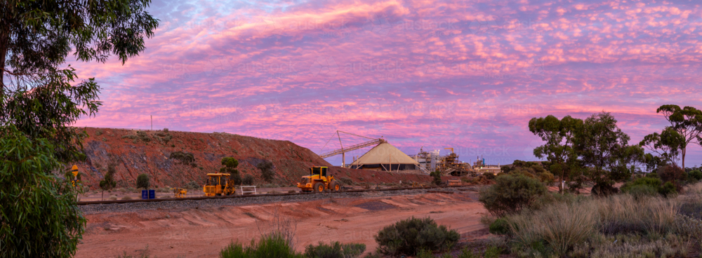 Image of Sunset panorama of mine site and heavy machinery. - Austockphoto