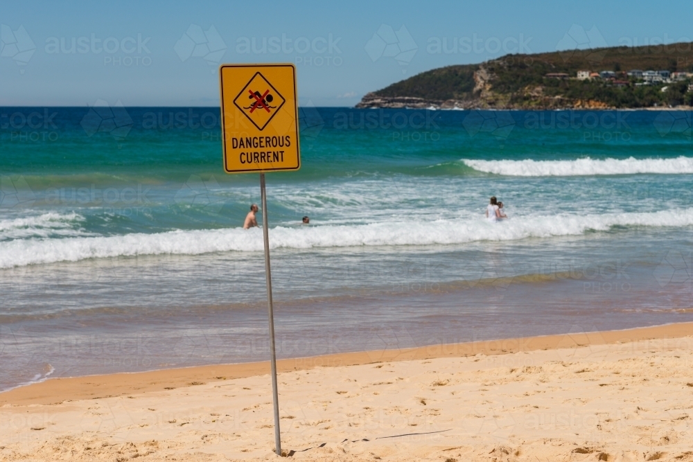 Image of surf sign reading dangerous current - Austockphoto