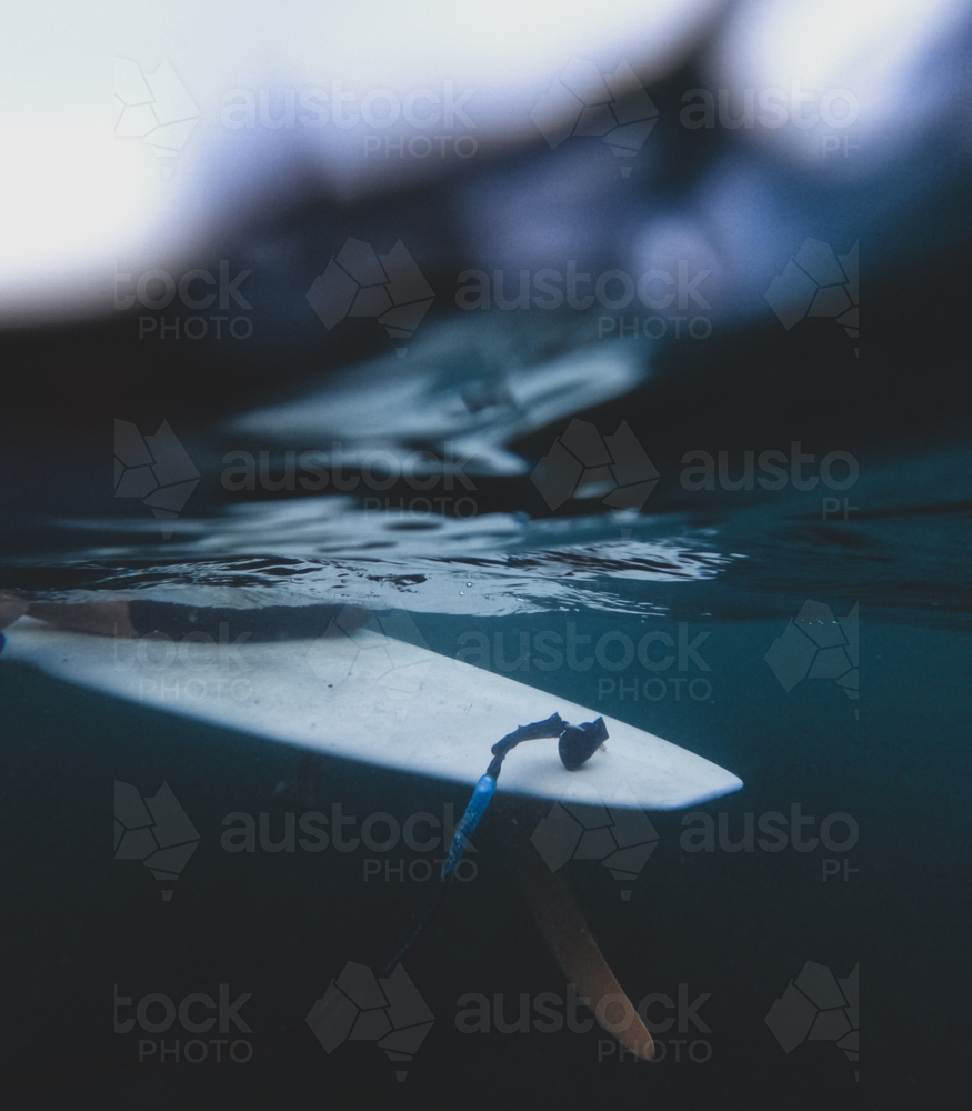 Image of Surfboard tail and fin underwater split view with sky and ...