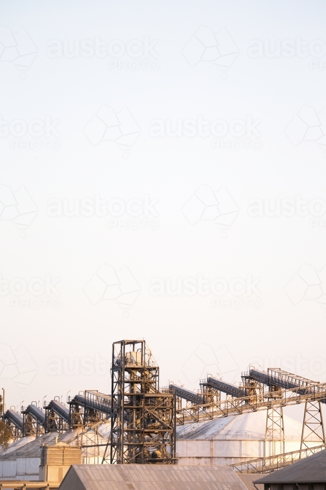 Image of tall steel tower with metal works around it and silos under ...