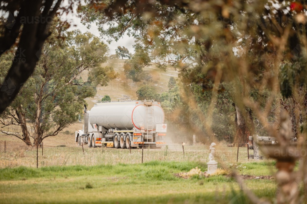 Image of Tanker truck leaving rural farm property after delivering fuel ...