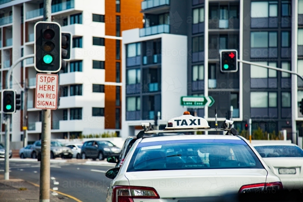 Image of Taxi car driving through green traffic light in city ...