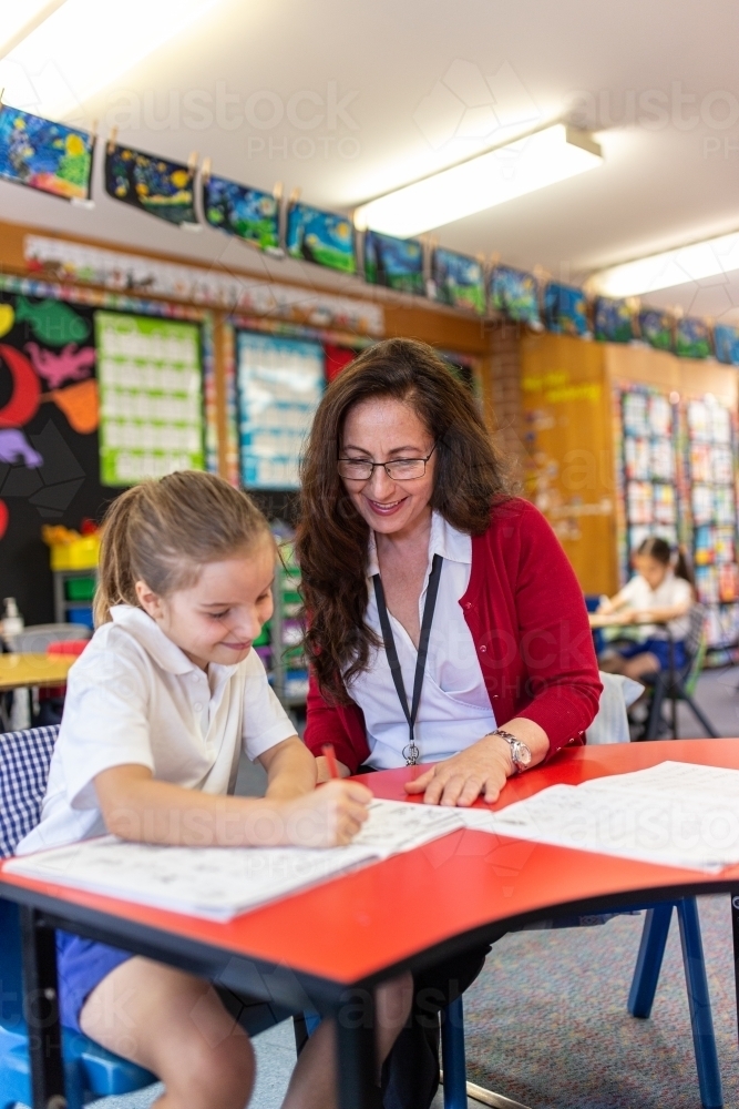 Image of Teacher and Student Working Together in Classroom - Austockphoto