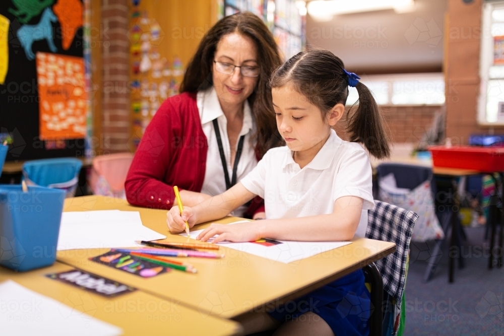Image of Teacher Helping Young Girl to Draw - Austockphoto