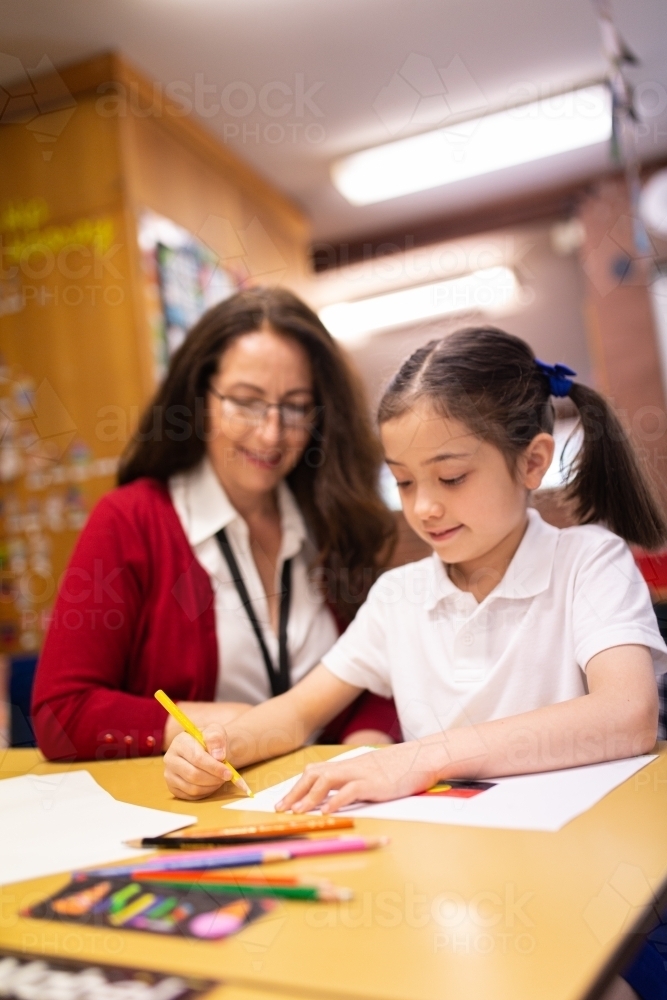 Image of Teacher Helping Young Schoolgirl to Draw - Austockphoto