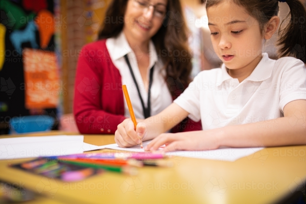 Image of Teacher Helping Young Schoolgirl to Draw - Austockphoto