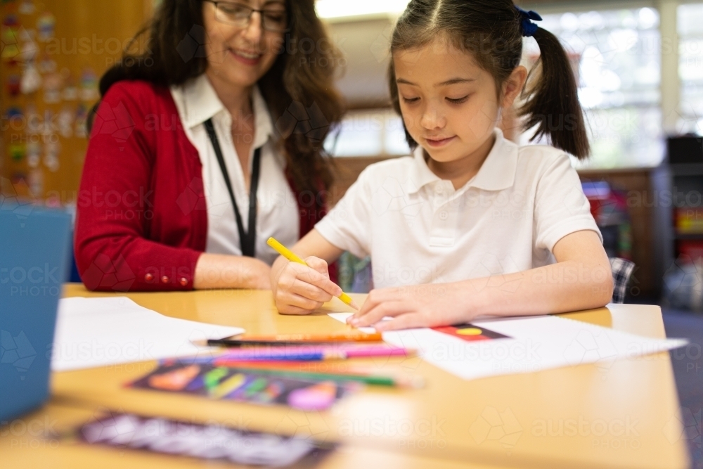 Image of Teacher Helping Young Schoolgirl to Draw - Austockphoto