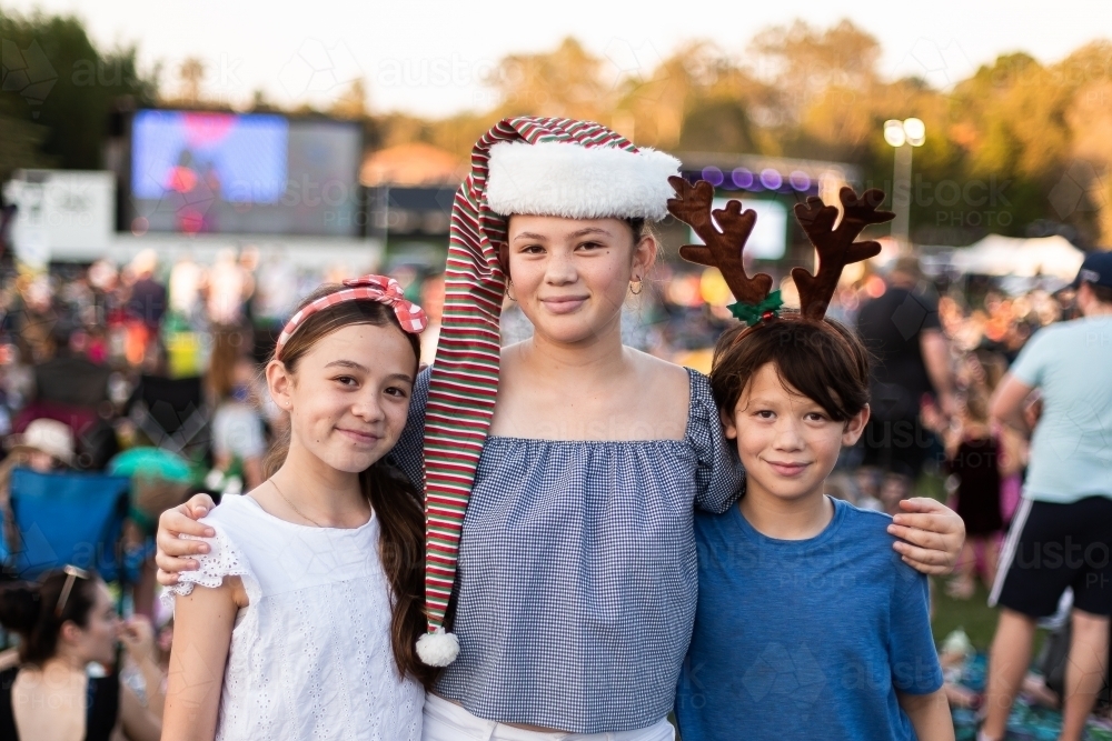 Image of teen and tween siblings smiling at the camera at a Christmas ...