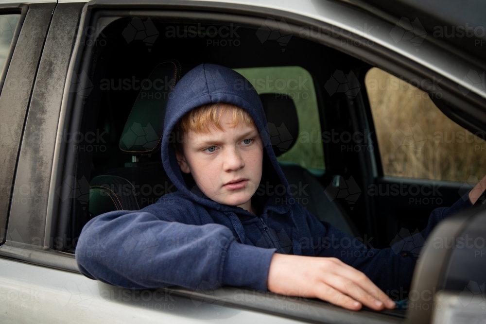 Image of Teen boy driving ute on farm - Austockphoto
