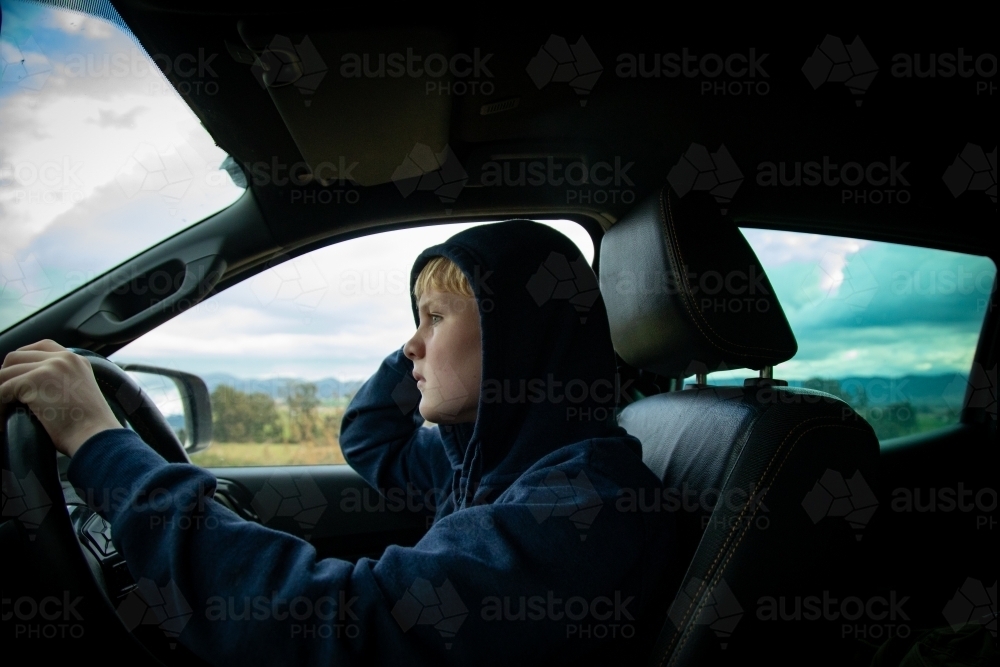 Image of Teen boy driving ute on farm - Austockphoto