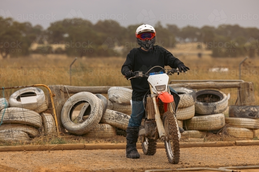 Image of Teen boy riding motorbike at motocross track meet - Austockphoto