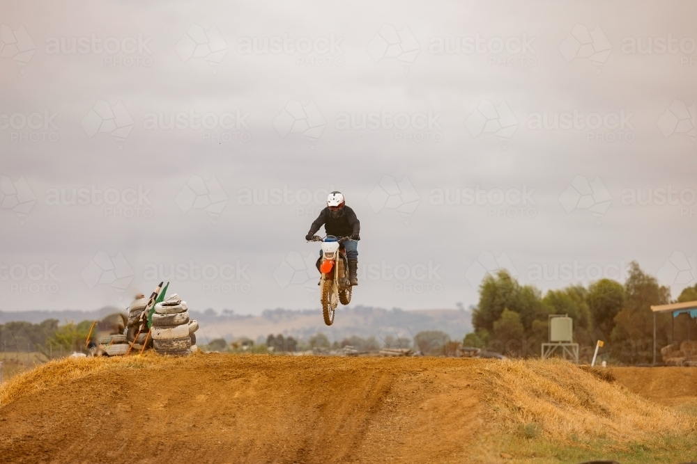Image of Teen boy riding motorbike at motocross track meet - Austockphoto