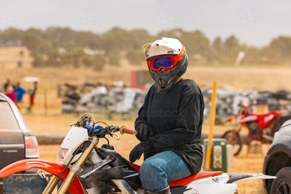 Image of Teen boy riding motorbike at motocross track meet - Austockphoto