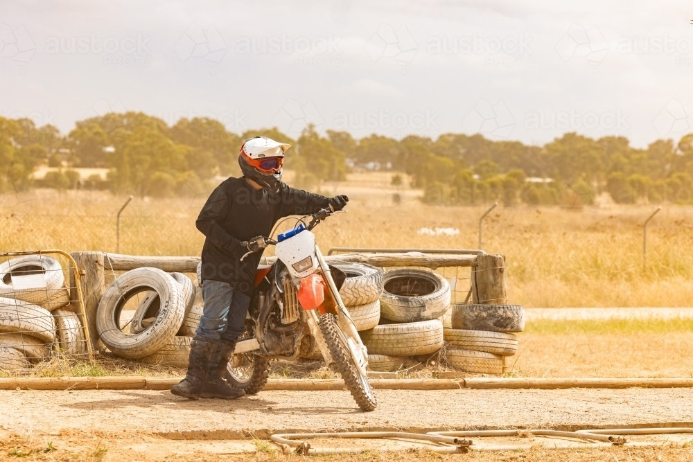 Image of Teen boy riding motorbike at motocross track meet - Austockphoto