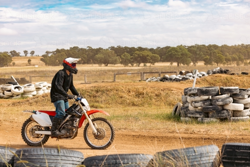 Image of Teen boy riding motorbike at motocross track meet - Austockphoto