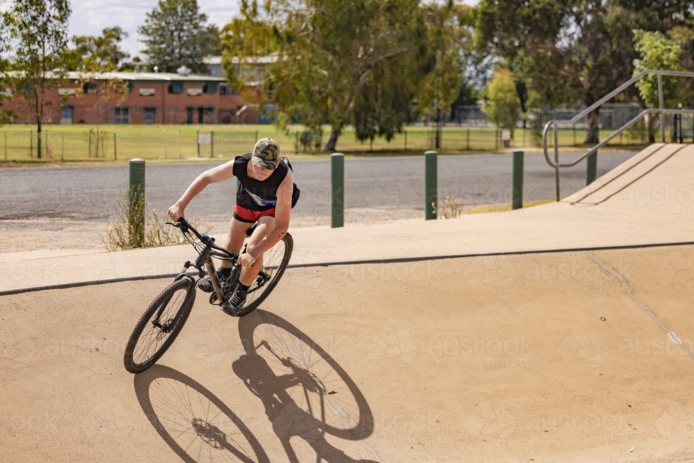 Image of Teen boy riding mountain bike at skate park - Austockphoto