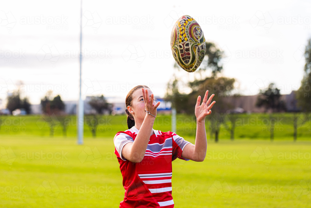 Image of Teen female Australian rules football player throwing footy ...
